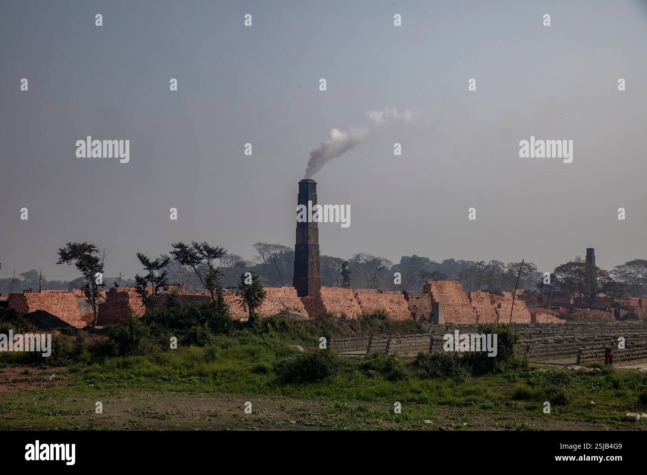 Thick smoke rises from brick kilns along the banks of the Shitalakshya ...