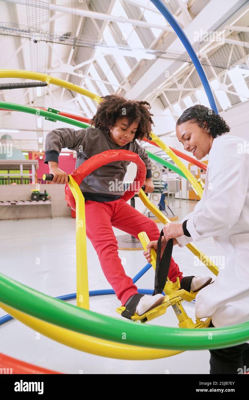 Instructor assisting girl on gyroscope at science center Stock Photo ...