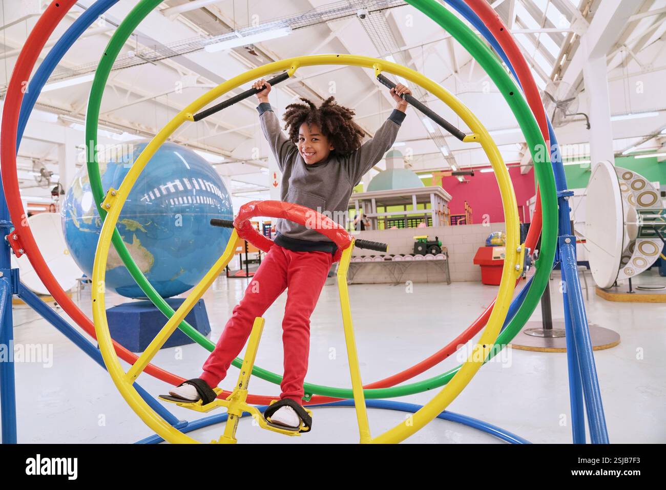Girl having fun on gyroscope at science center Stock Photo - Alamy