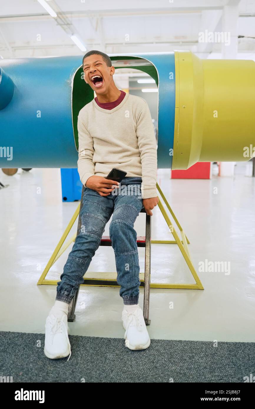 Laughing man sitting on ladder, holding smart phone Stock Photo - Alamy