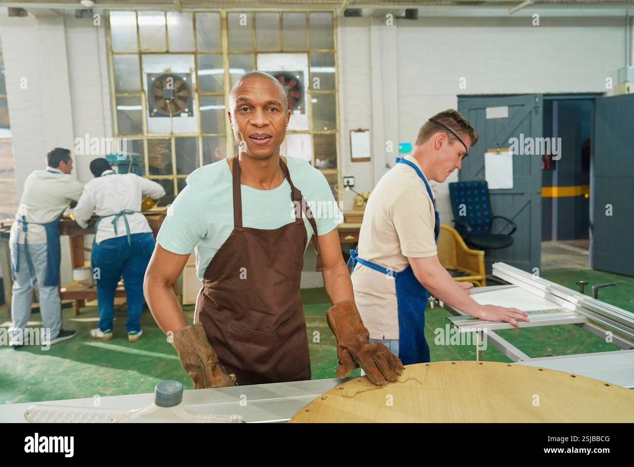 Group of craftsmen working in woodshop Stock Photo - Alamy