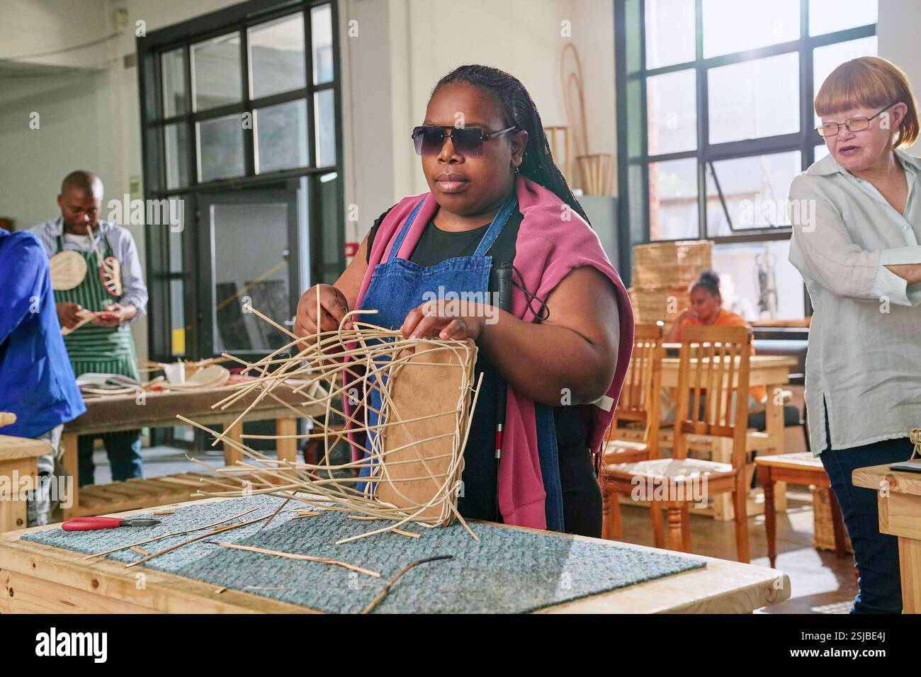 Visually impaired people weaving wicker Stock Photo - Alamy