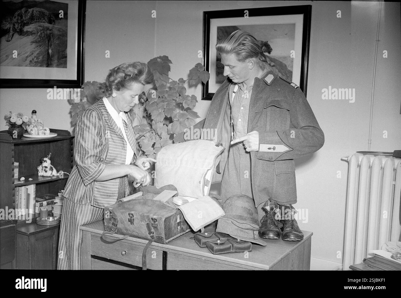 Mobilmachungs-Reportage 1947: Der Einberufene packt mit der Mutter/Frau ...