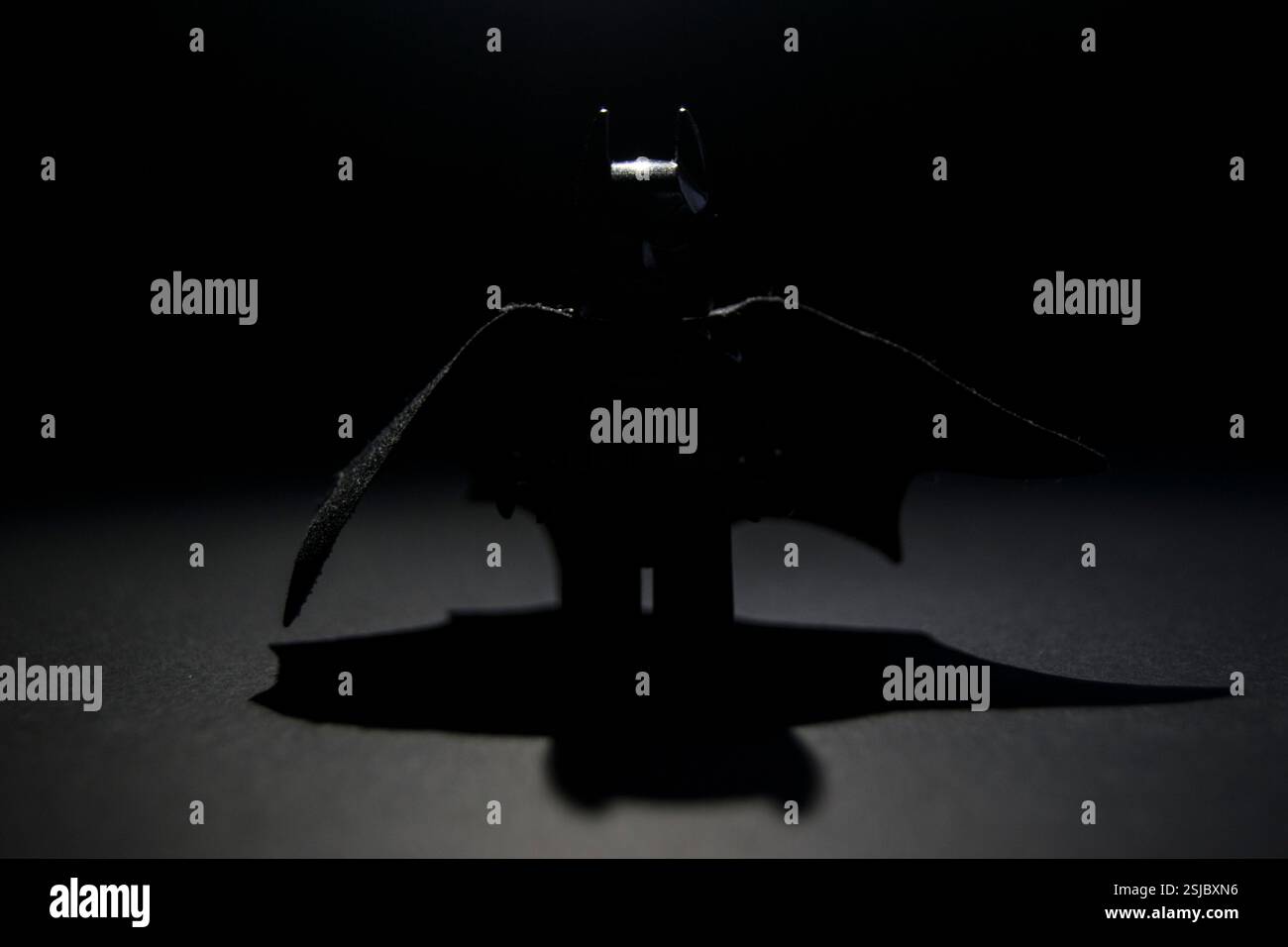 Lego Batman minifigure in dramatic flight pose with cape spread wide ...