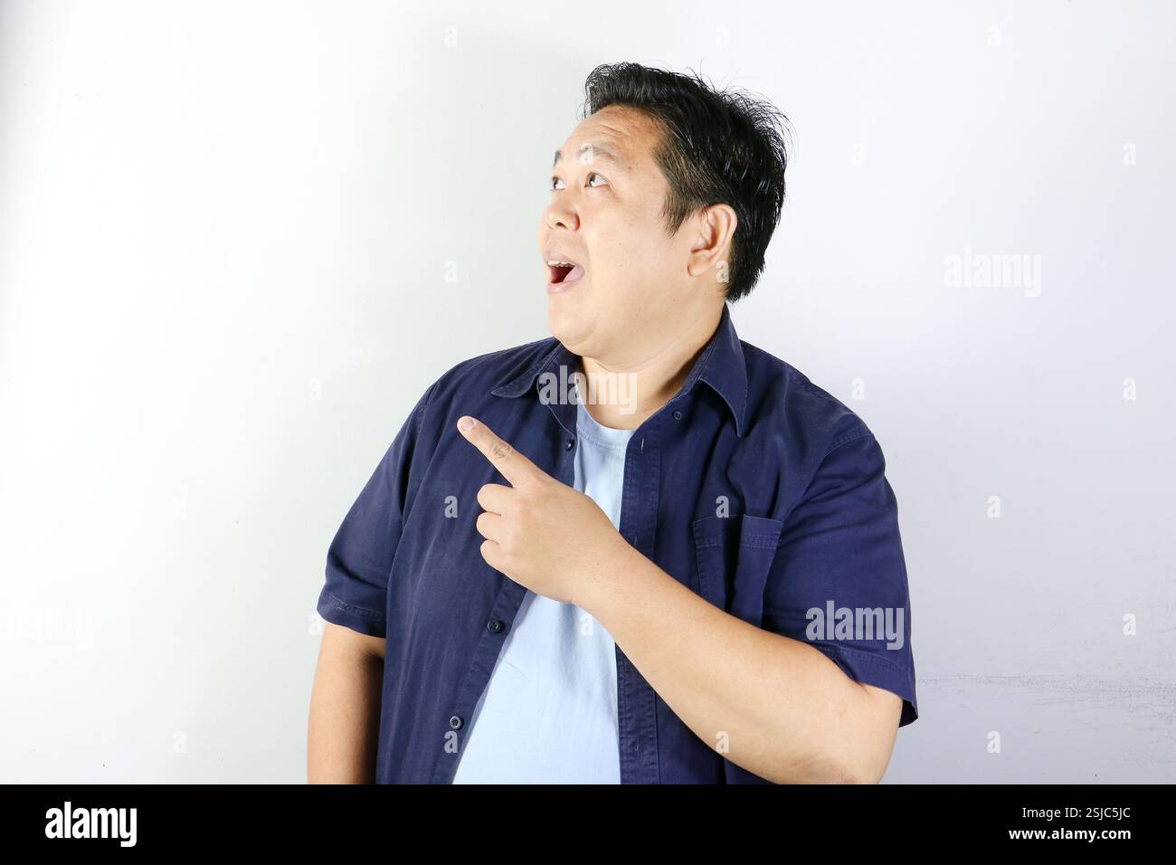 Surprised Man Pointing Upward over isolated white background Stock ...
