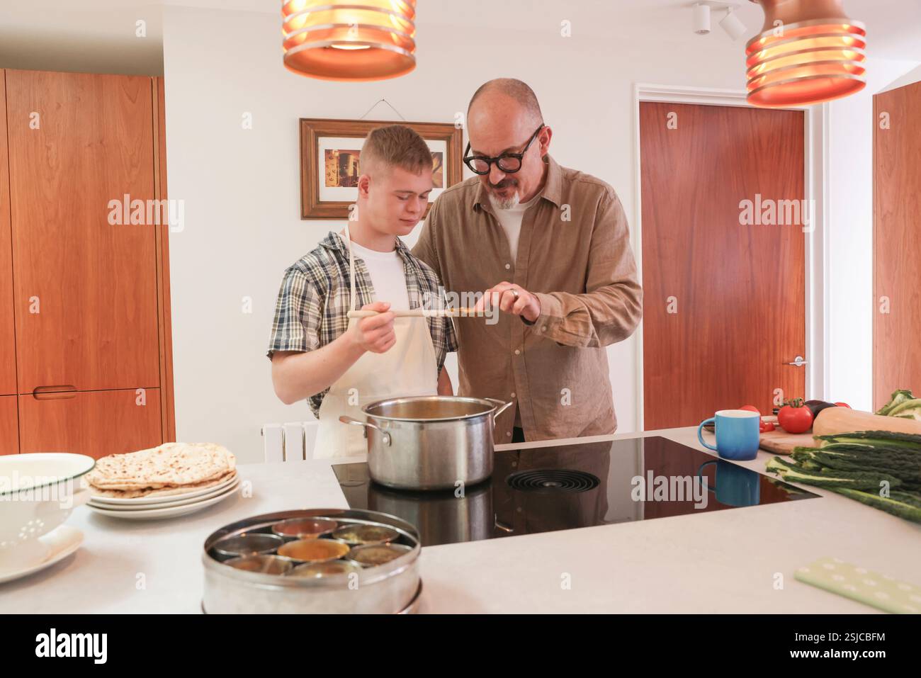 Father cooking with adult son Stock Photo - Alamy