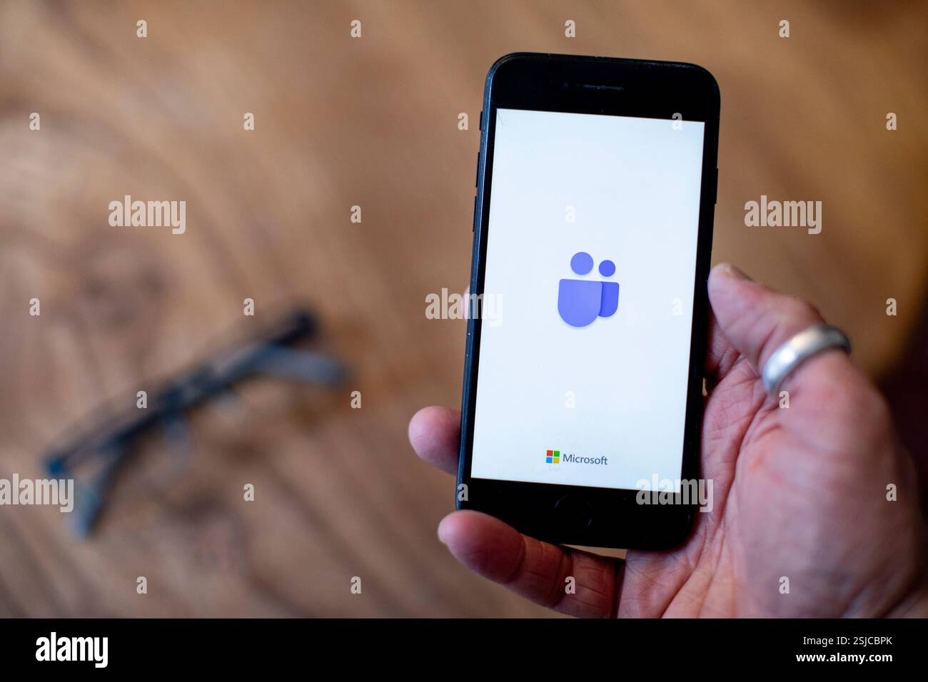 A mobile phone being held showing the Microsoft Teams app open on ...