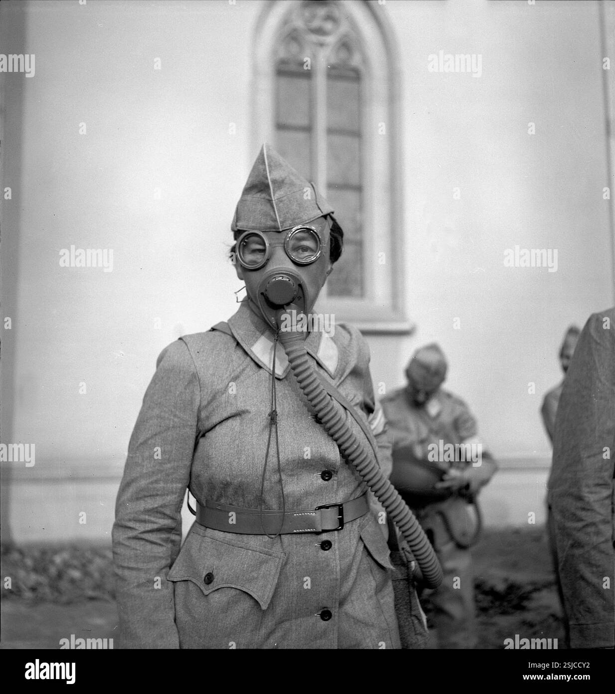 Frau trägt Gasmaske; FHD im Luftschutz; 1945#Woman wearing gas mask ...