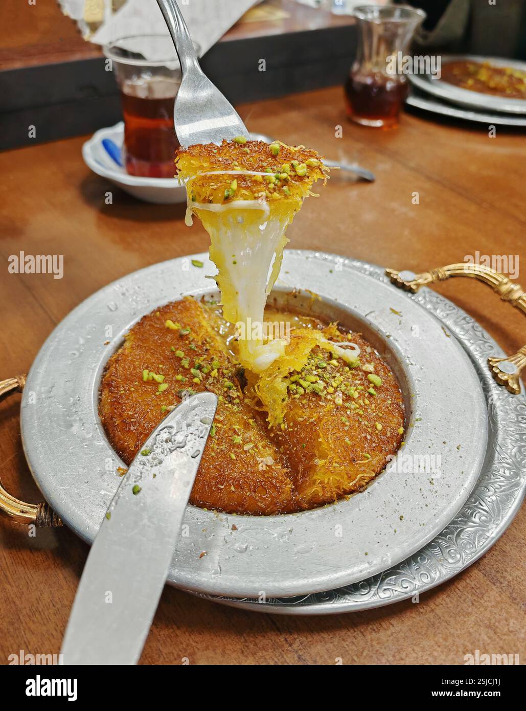 Turkish dessert kunefe, kunafa, kadayif with pistachio powder and ...