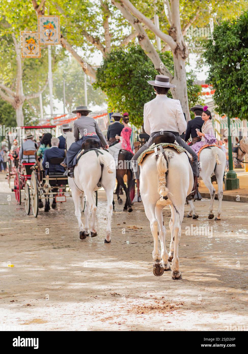 Group of Spanish riders in traditional attire on horseback at an ...