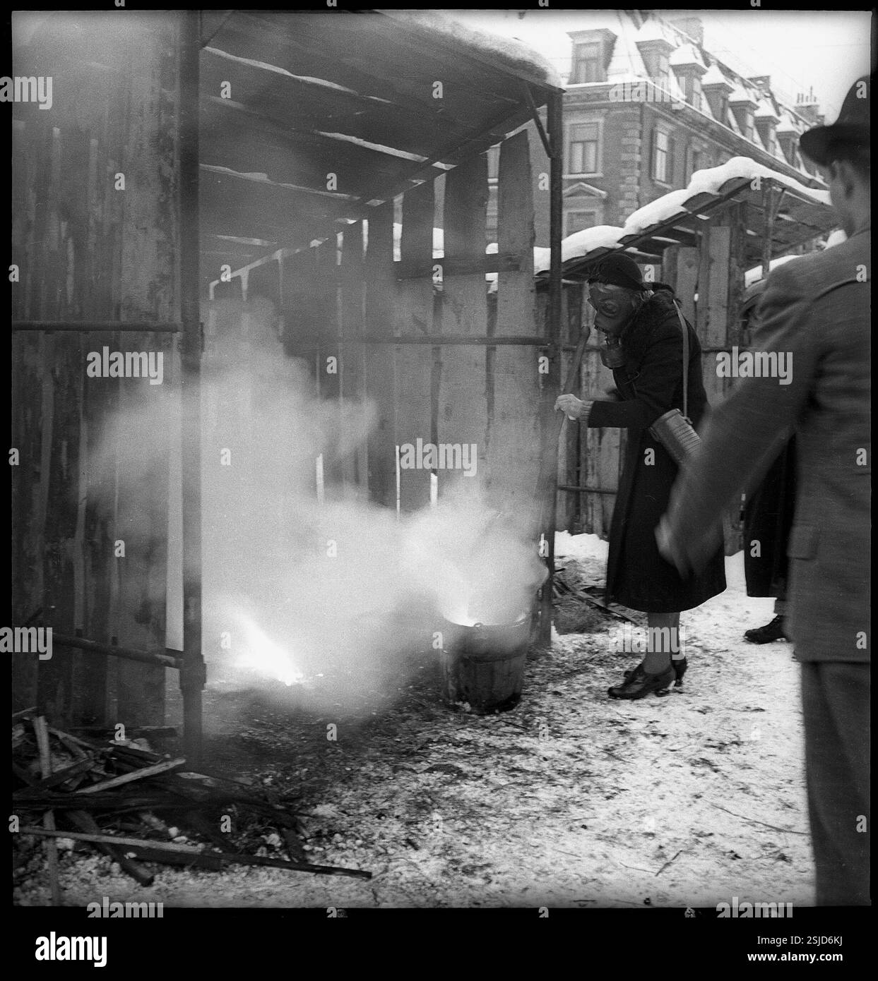 Instruktion der Hausfeuerwehr: Frau beim Löschen, 1940#Instruction of ...