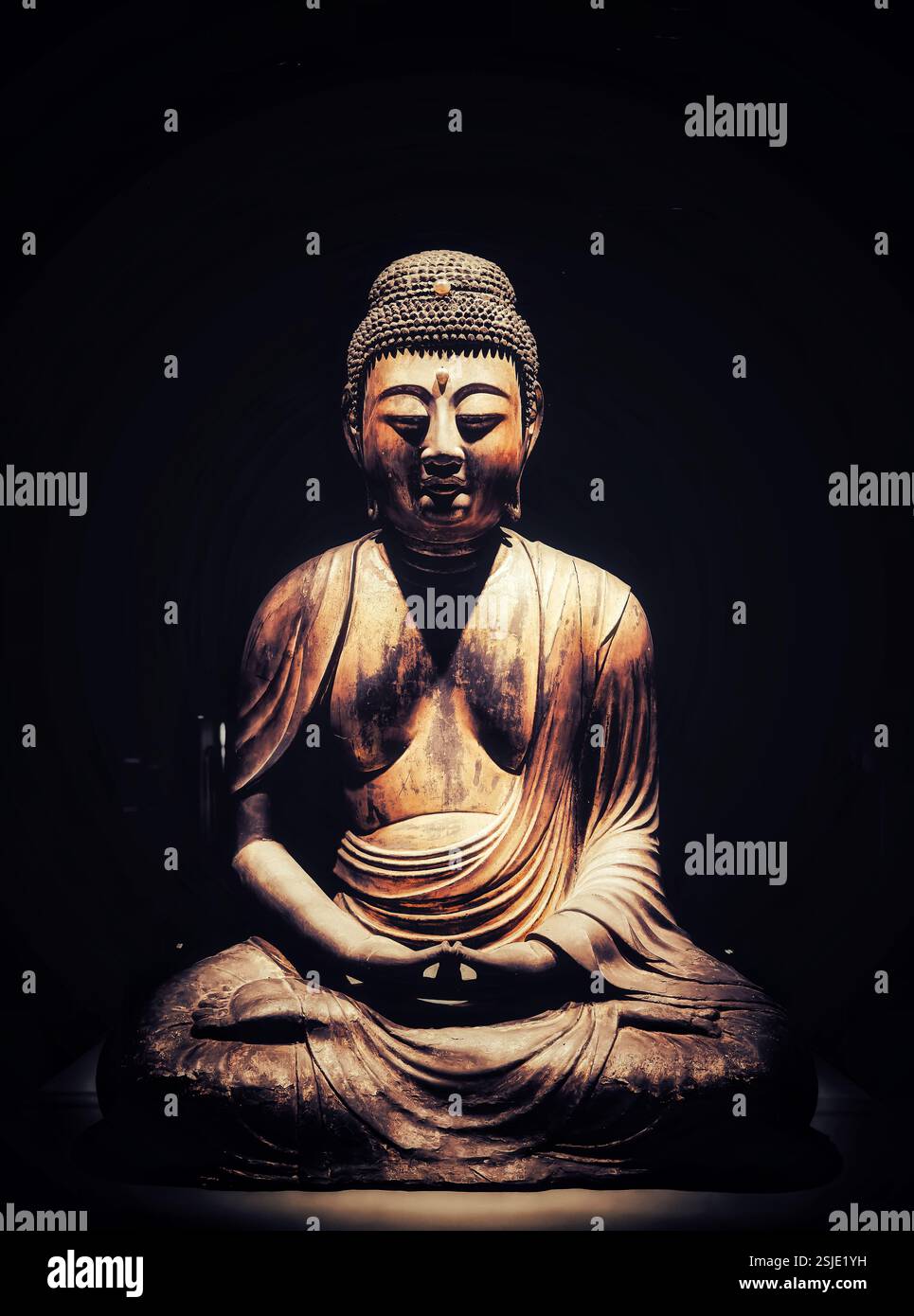 The image showcases a bronze statue of Buddha, seated in a meditative ...