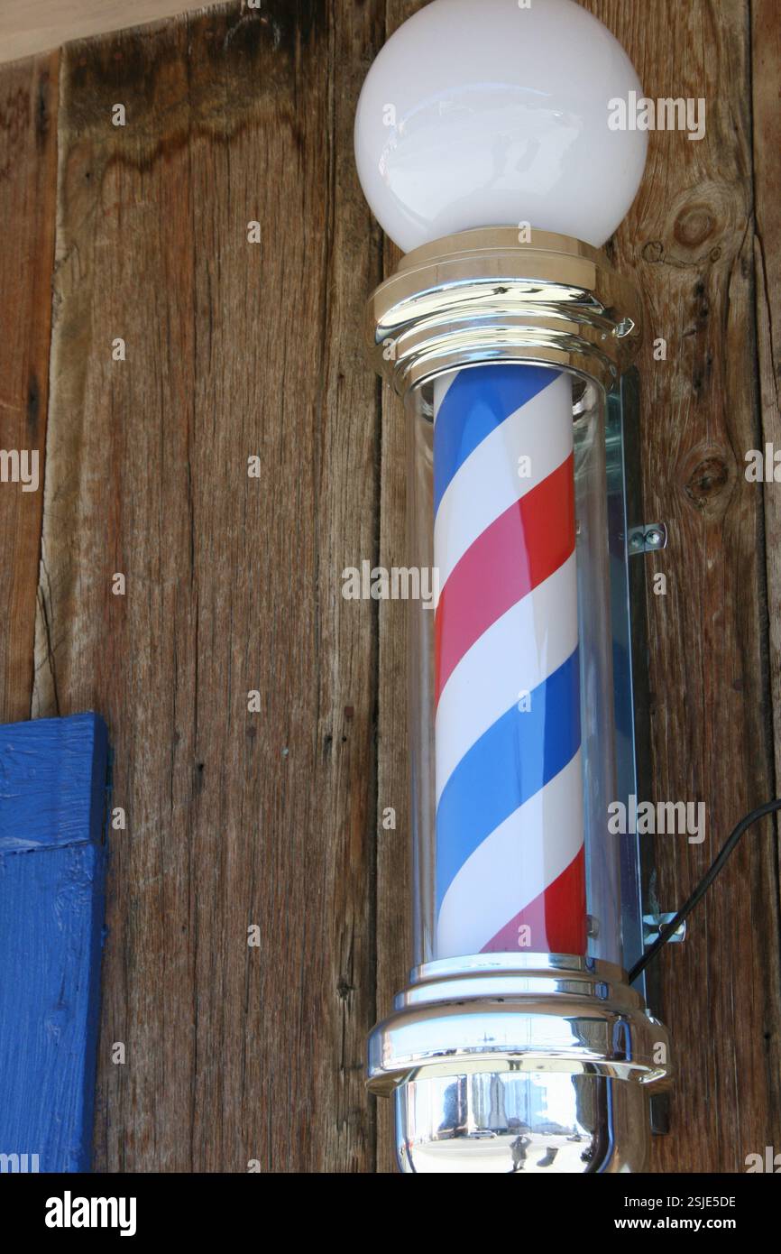 An iconic barber pole on the outside of a building. The symbol for a ...
