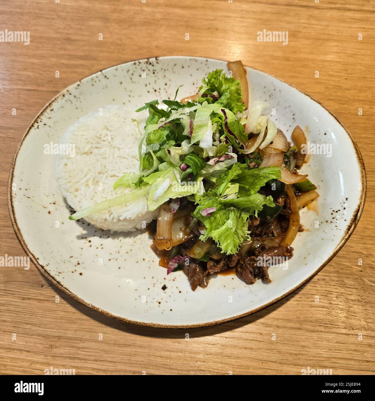 A colorful plate of vietnamese stirfried beef, fresh vegetables, and ...