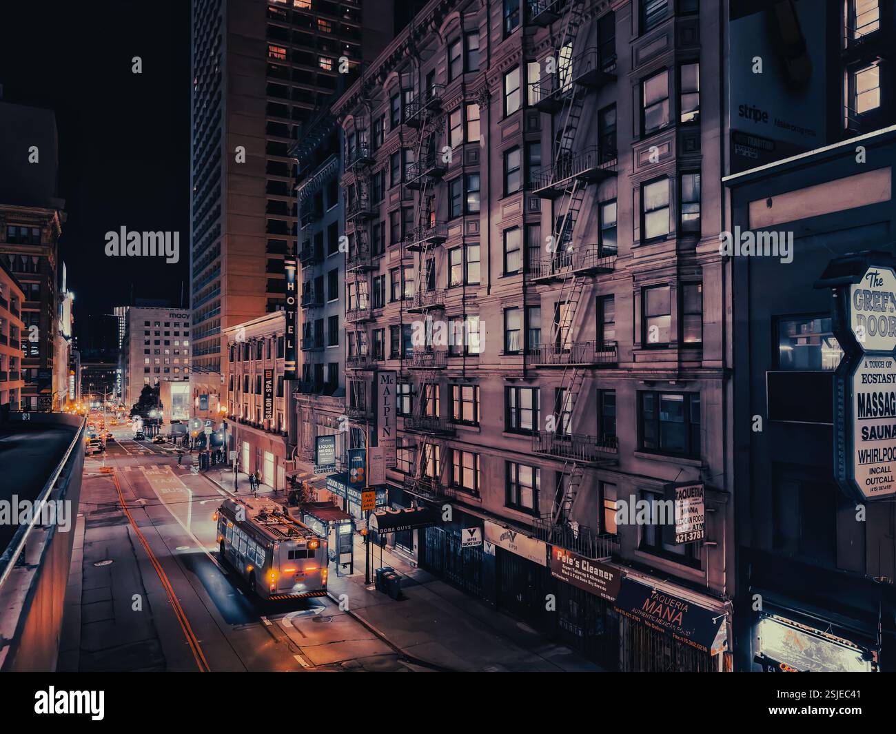 The image captures a bustling San Francisco street at night ...