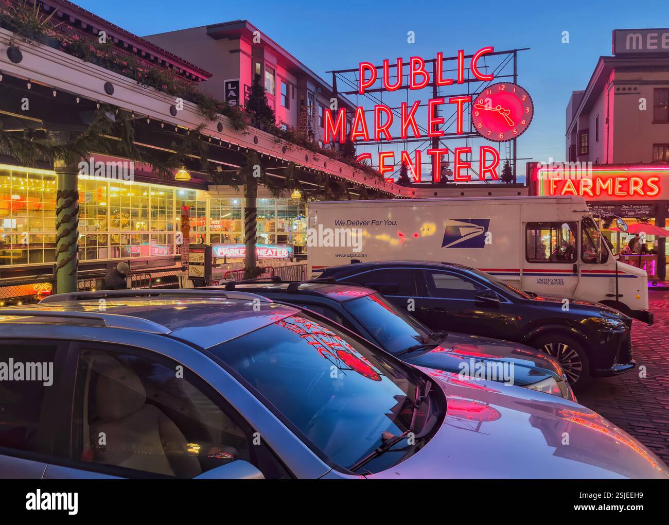 A nighttime view of the Seattle Pike Market Center, with a large neon ...