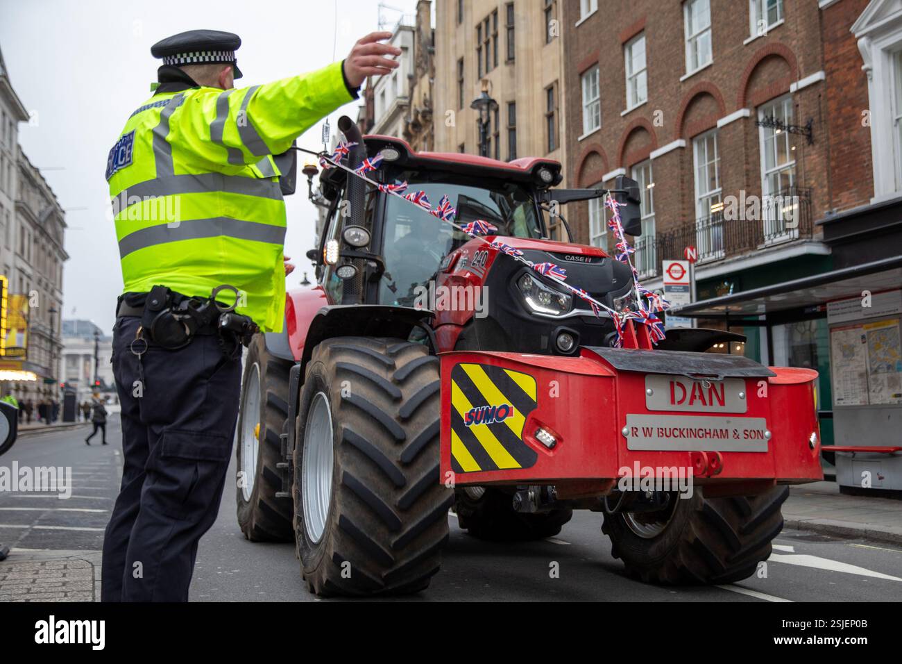 A police officer gives direction to a tractor participating in the ...