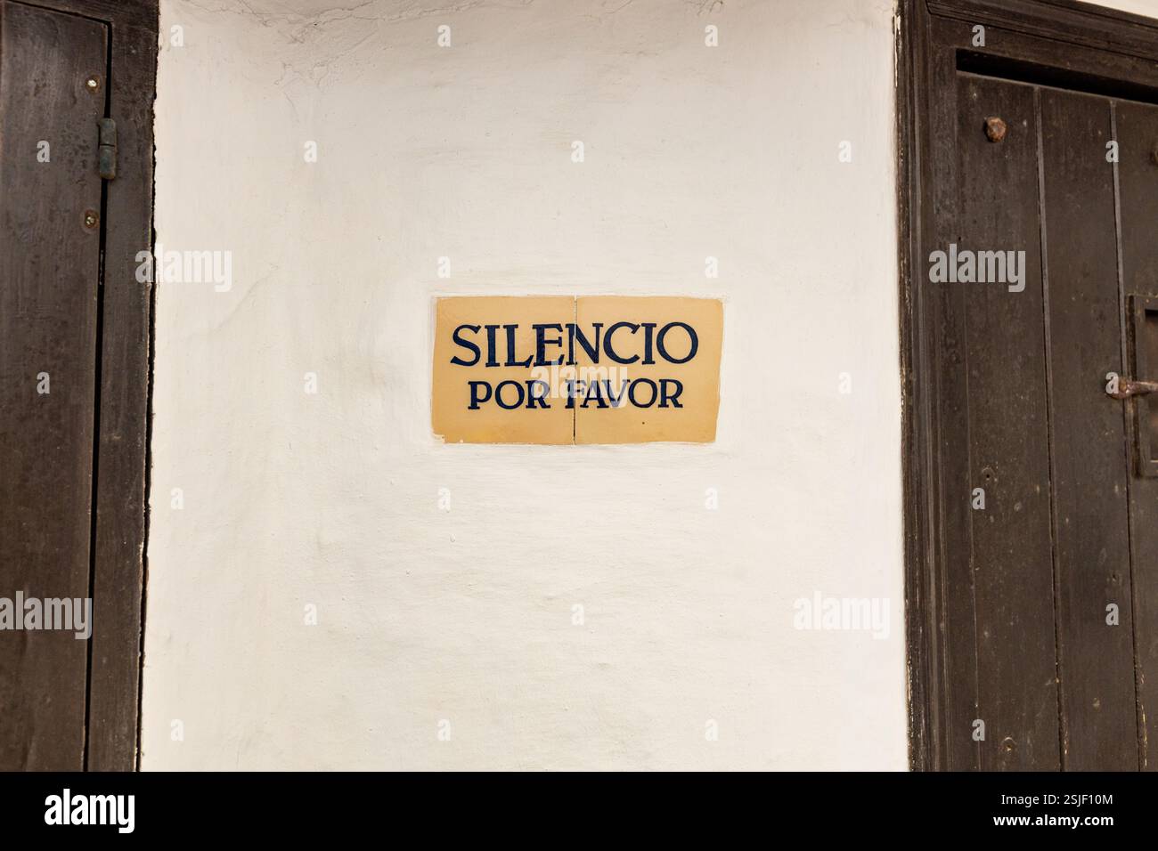 A sign saying Please be quiet in Spanish (Silencio por favor) on a ...