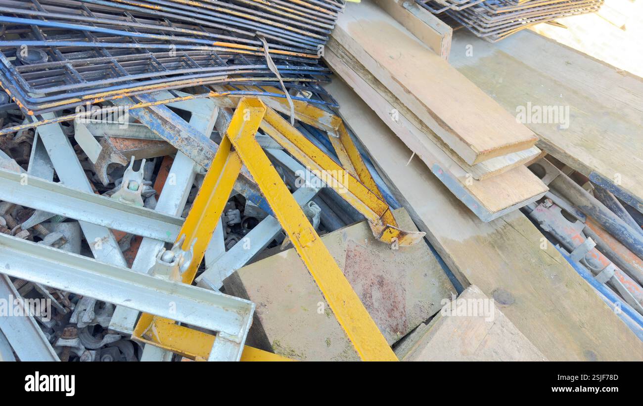 Pile of mixed construction debris including rusted metal framework ...