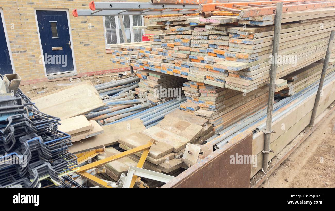 Construction site debris and materials including stacked scaffolding ...