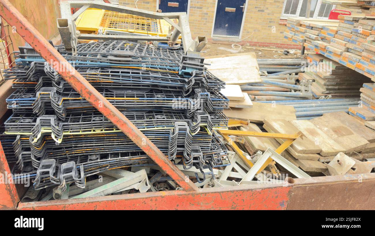 A rusty red container holds a jumbled assortment of construction ...