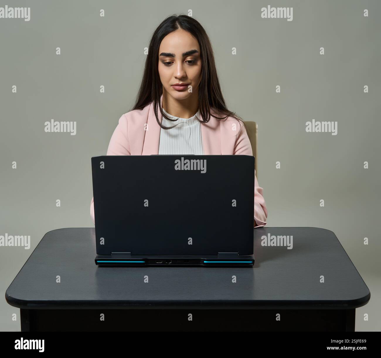 Focused businesswoman working on a laptop at a desk, showcasing ...