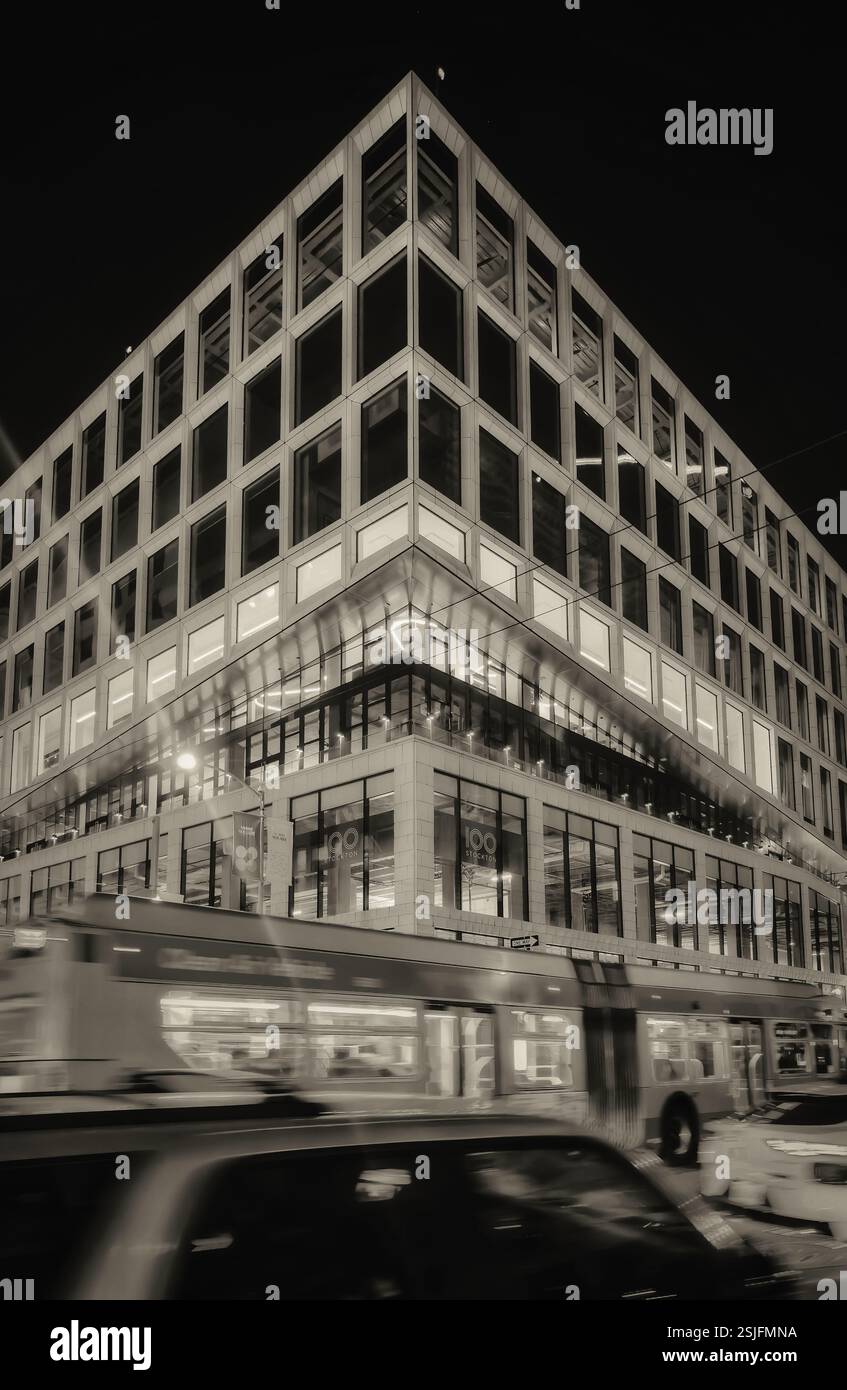 A modern, angular building with a grid of windows dominates the image ...