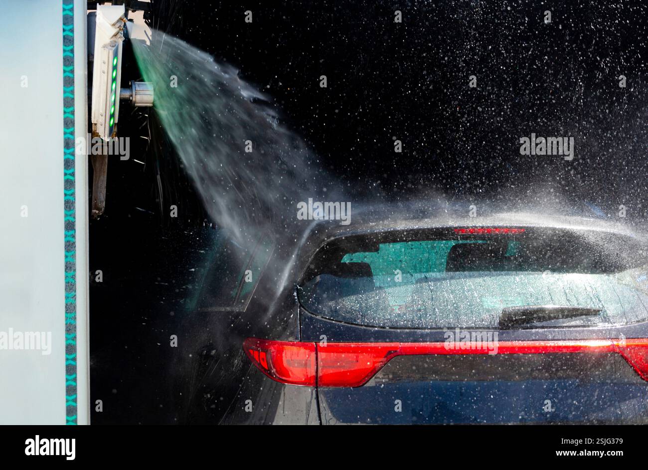 Contemporary vehicle is getting cleaned in an automated car wash center ...