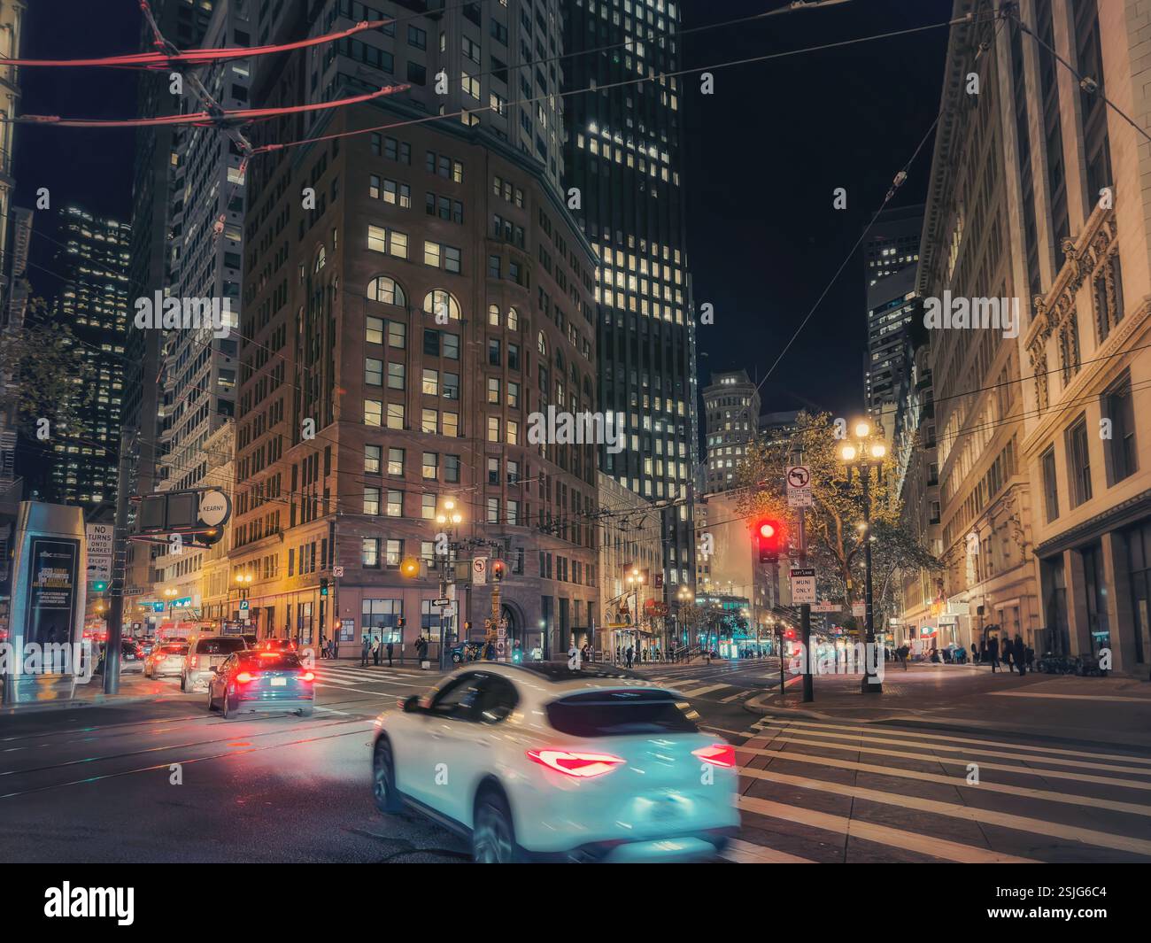 The image captures a bustling San Francisco street at night ...