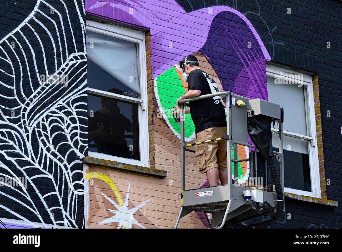 Man painting mural on wall at the Royal Mews car park, Alexandra Street ...