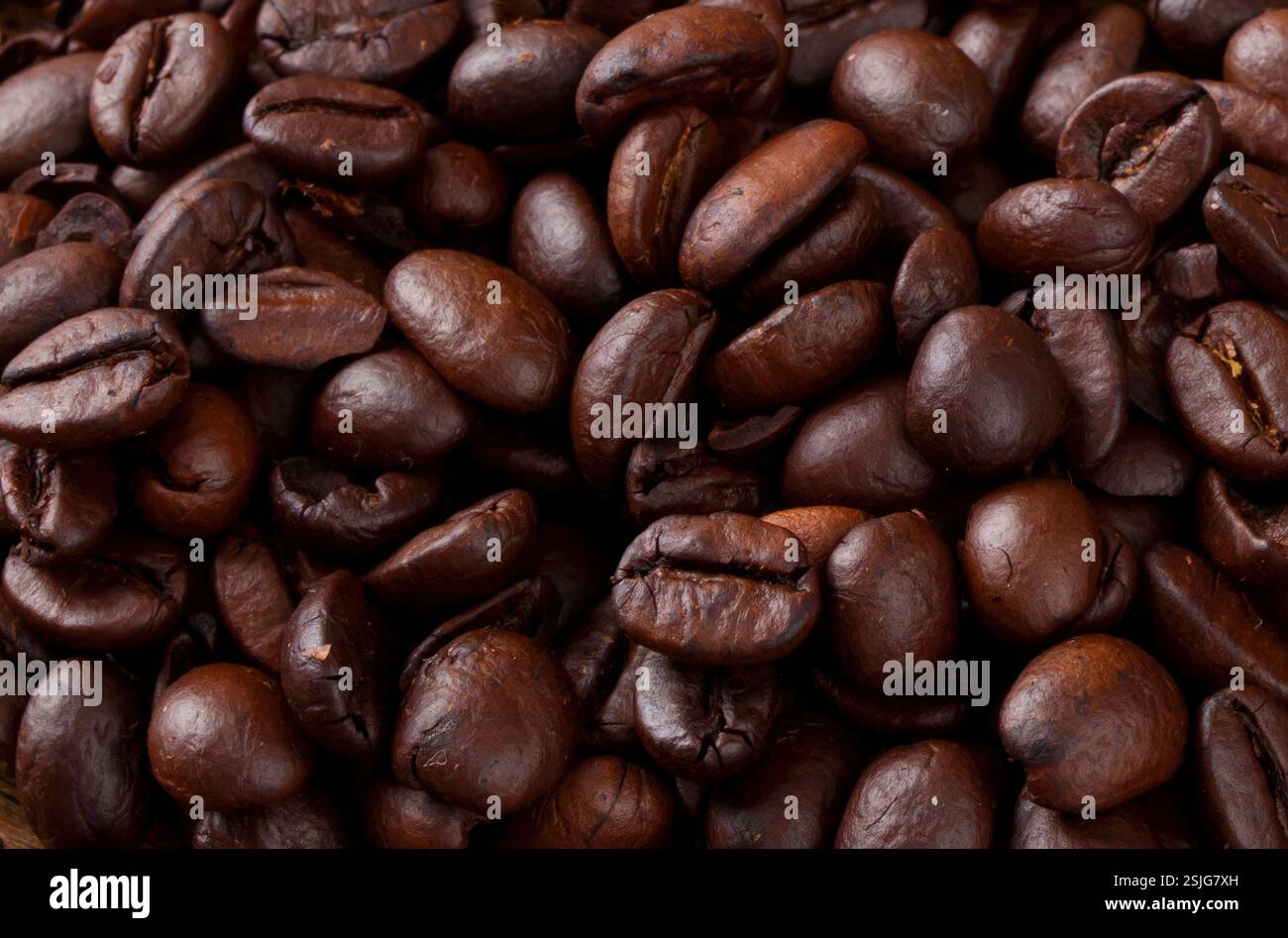Dark roasted coffee beans creating a rich background hi-res stock ...