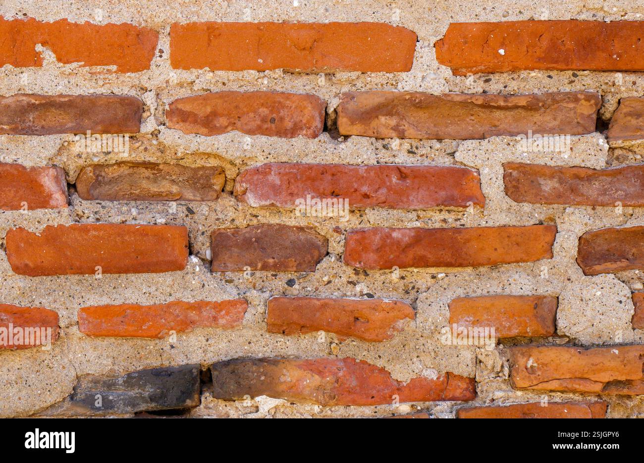 Weathered bricks of various shades are arranged in a traditional wall ...