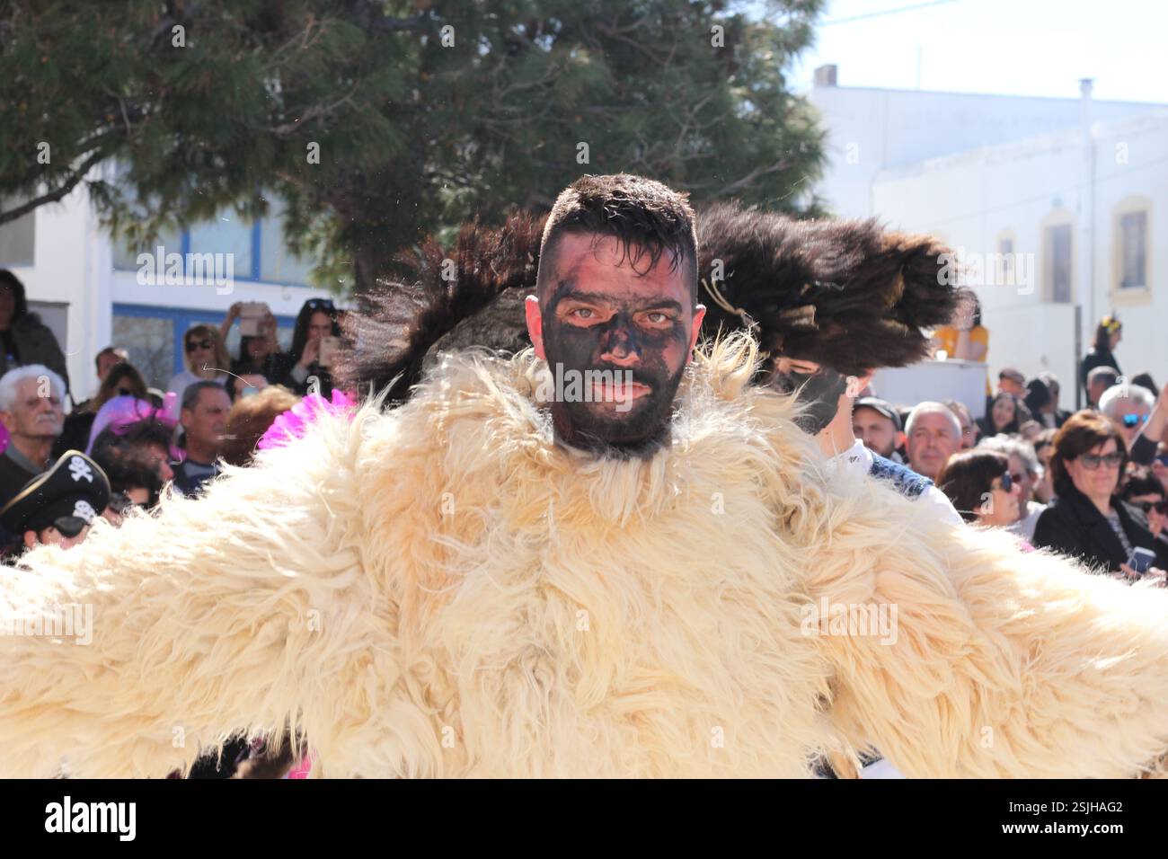 A young man dressed in a woolen costume with his face painted black ...