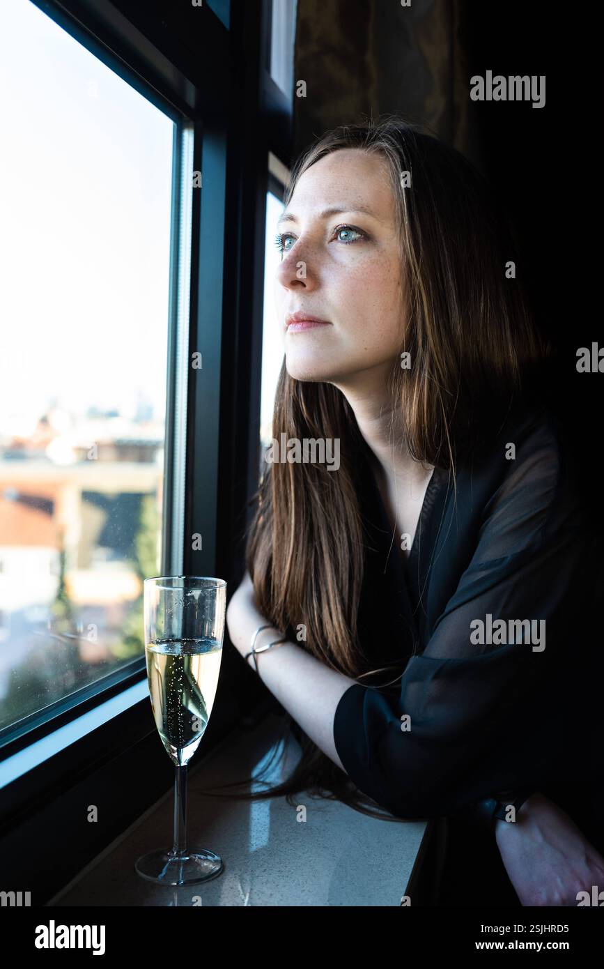 Business woman resting at the window with a glass of champaign, Belgium ...