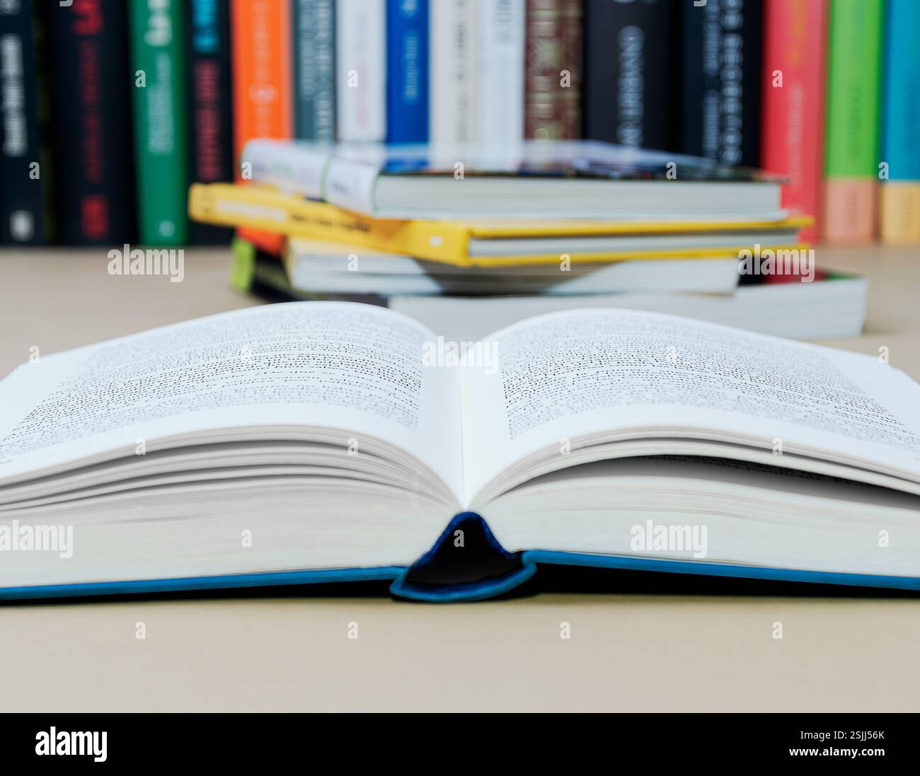 Open book with some blur on a counter and several out focus books in ...