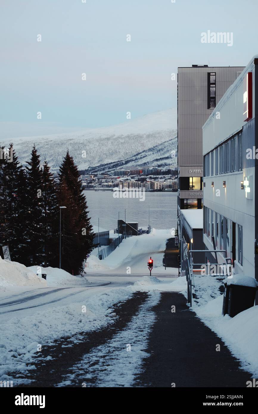 View down icy street to the waterfront in Tromso, Norway in winter ...
