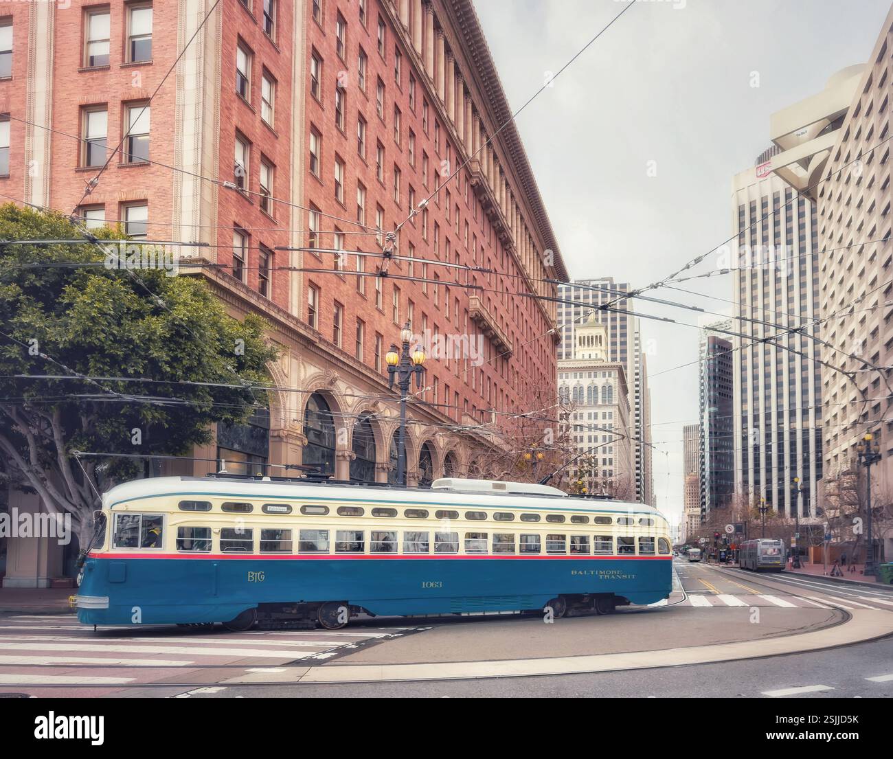 A vintage blue and cream streetcar travels along a city street in San ...