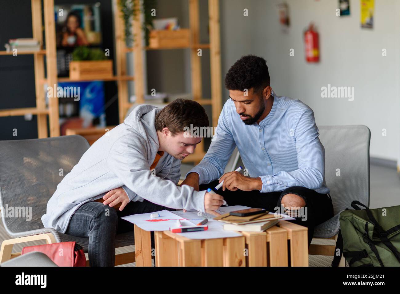 Young man with Down syndrome studyng with special educator teacher in ...