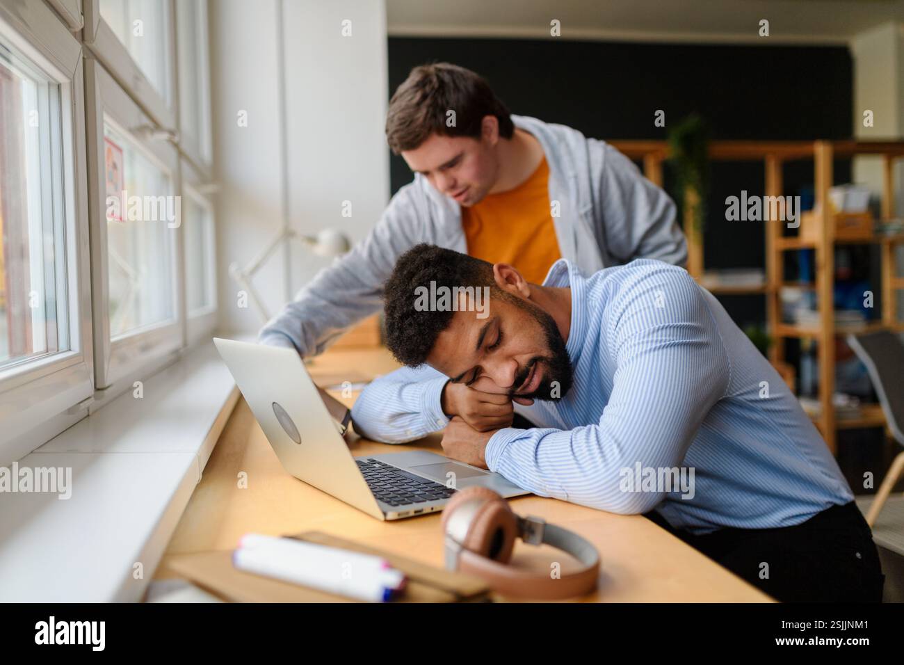 Tired young African-american teacher sleeping with head on desk Stock ...