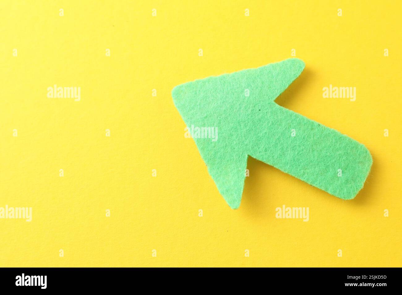 One green arrow on yellow background, top view. Space for text Stock ...