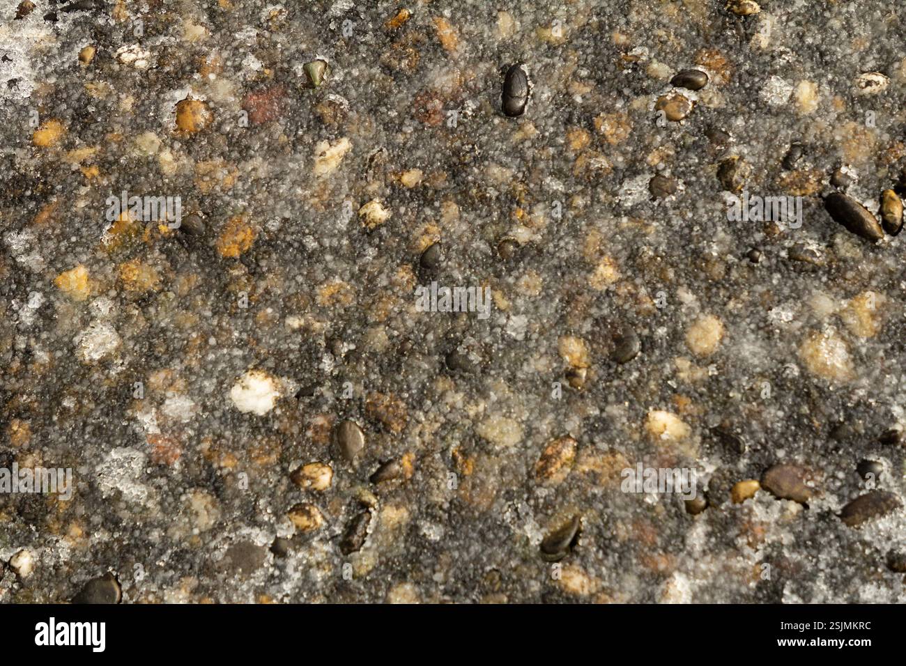 A close-up of frozen rocks covering a flat roof, part of a ballasted ...
