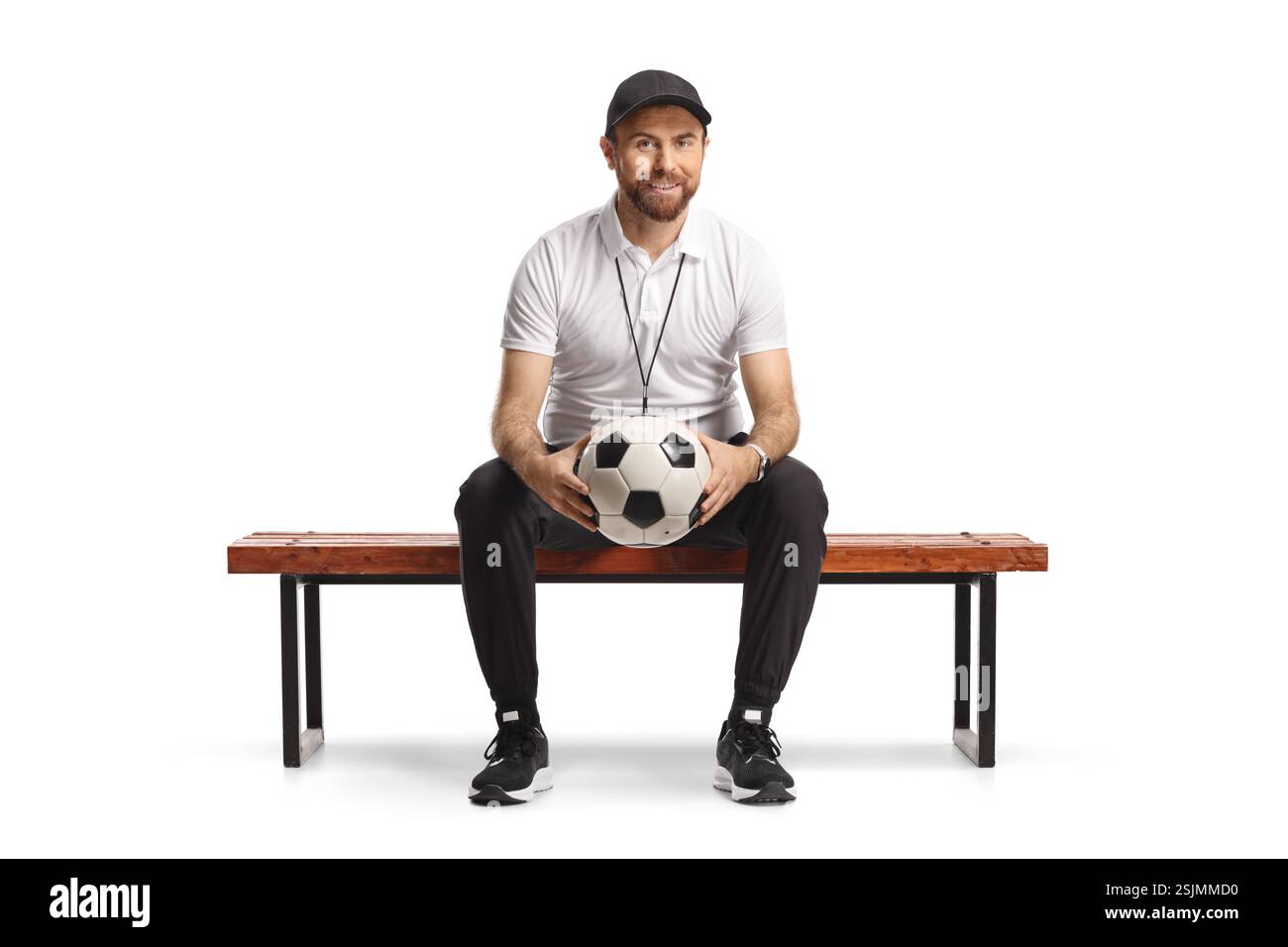 Football coach sitting on a bench and holding a ball isolated on white ...