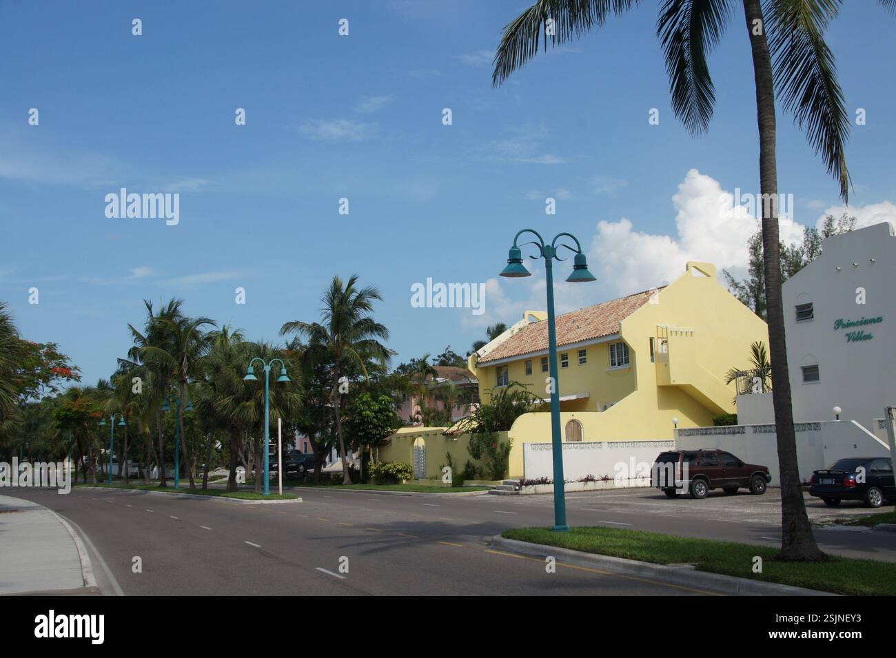 Street scene in the Bahamas. Yellow buildings with teal accents. Palm ...