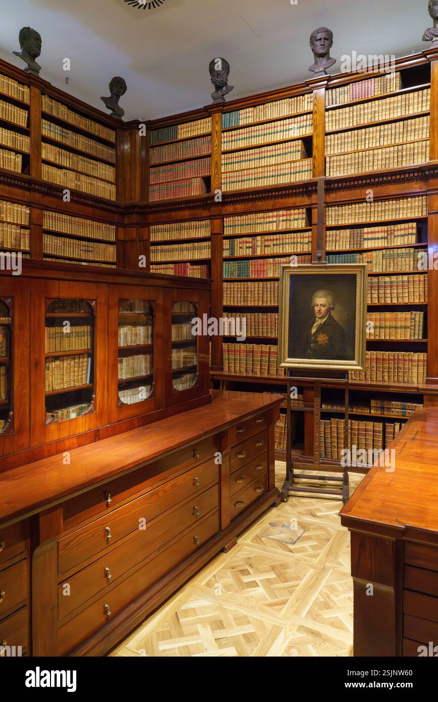 Interior of a historic library with many levels of shelves of old books ...