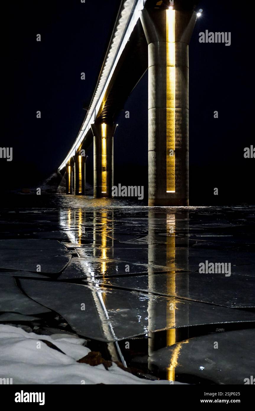 Lighted bridge at night. Reflection on the water and ice Stock Photo ...