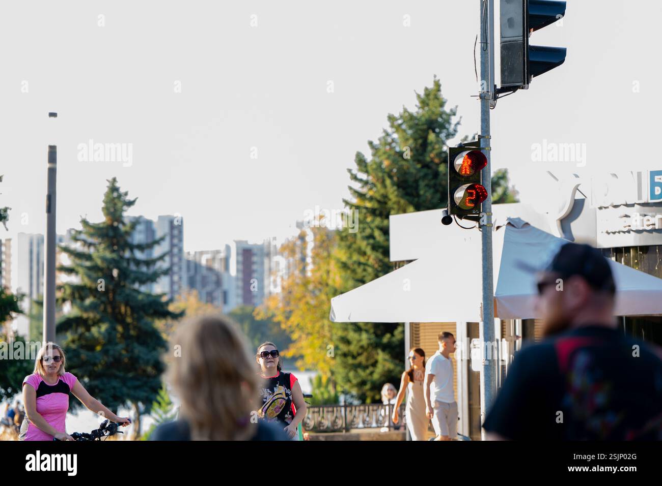 A crowd of people stands at a pedestrian zebra crossing and waits for ...