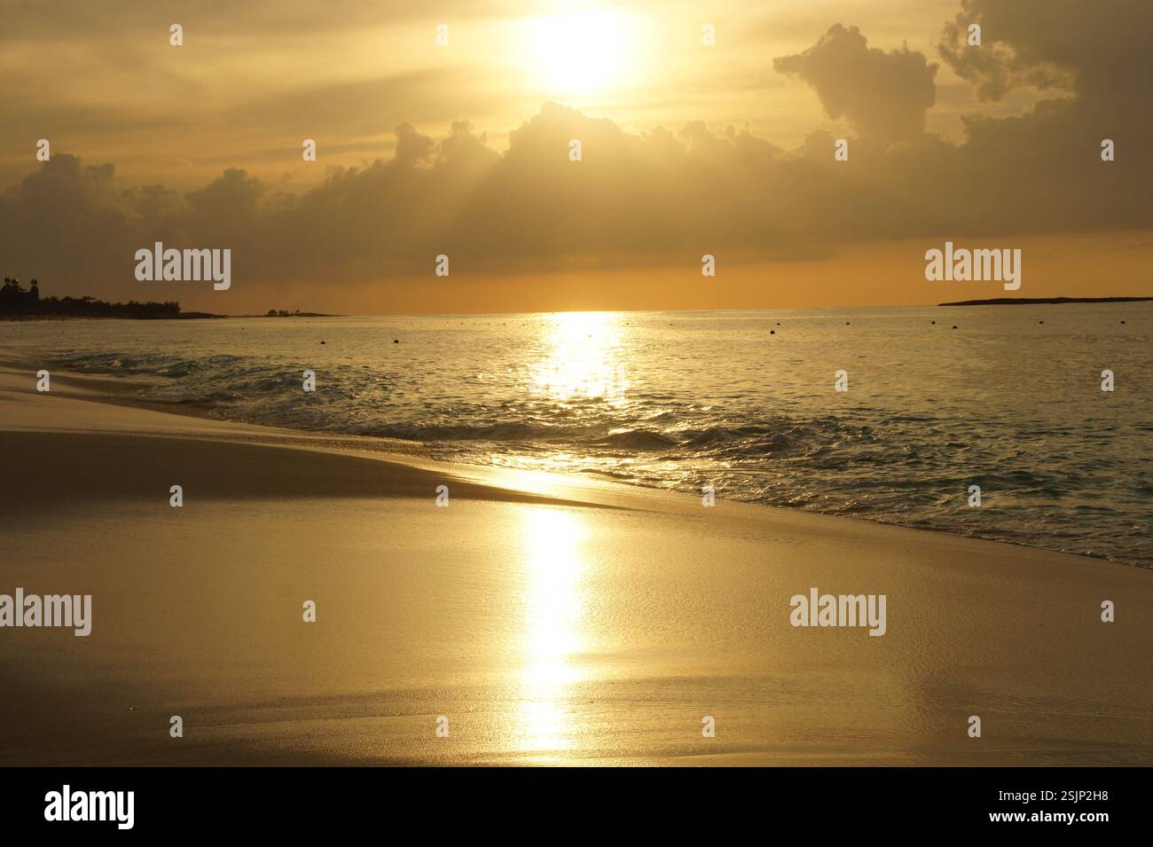 Beach Sunset Bahamas. Golden sky clouds reflect on calm ocean waves ...
