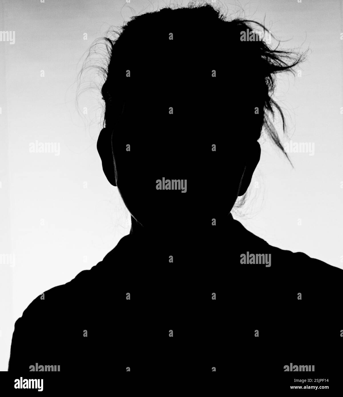 Silhouette of a woman against a bright background. The dark outline ...