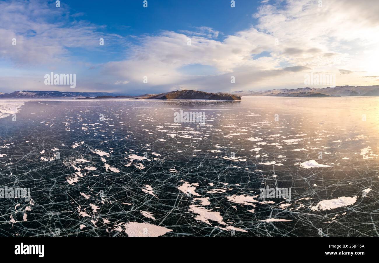 Aerial view on transparent frozen water, sunset in background ...