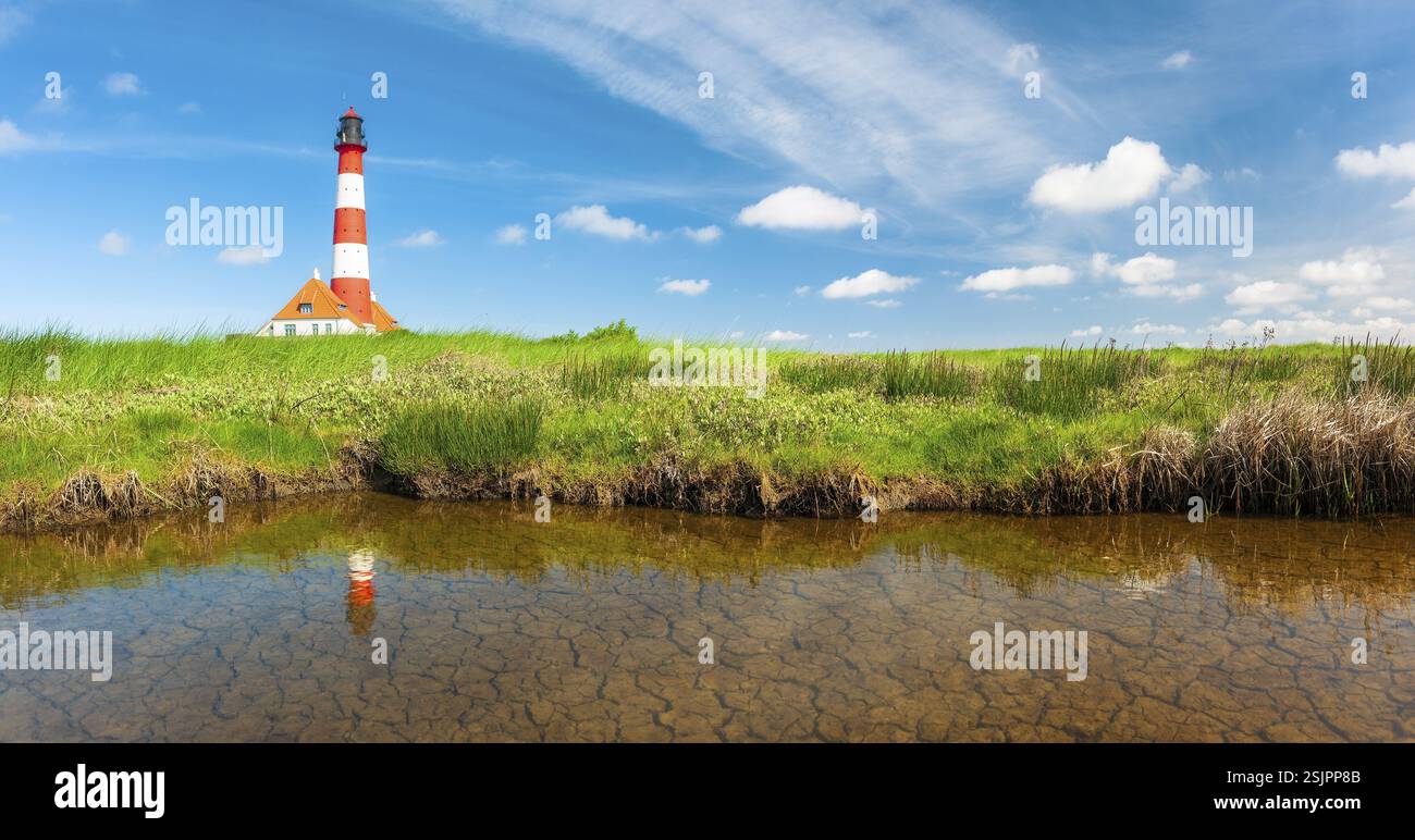The Westerheversand lighthouse under a blue sky with white clouds ...
